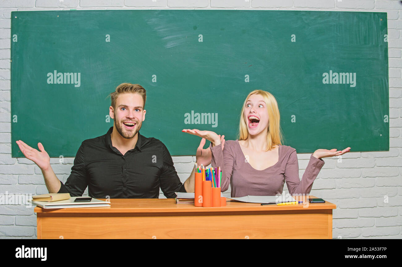 Happy and cheerful. Pretty teacher and handsome schoolmaster smiling at ...