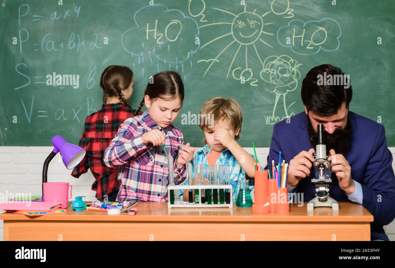 Fascinating chemistry lesson. Man bearded teacher and pupils with test ...