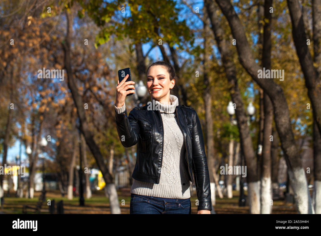 Calling by phone happy woman. Portrait of a young beautiful brunette ...