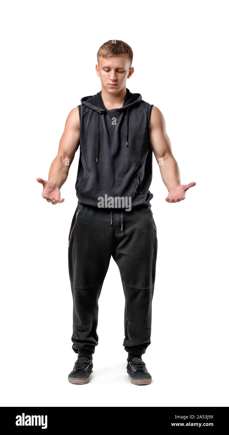 Muscled young man holding something in front of him and looking down ...