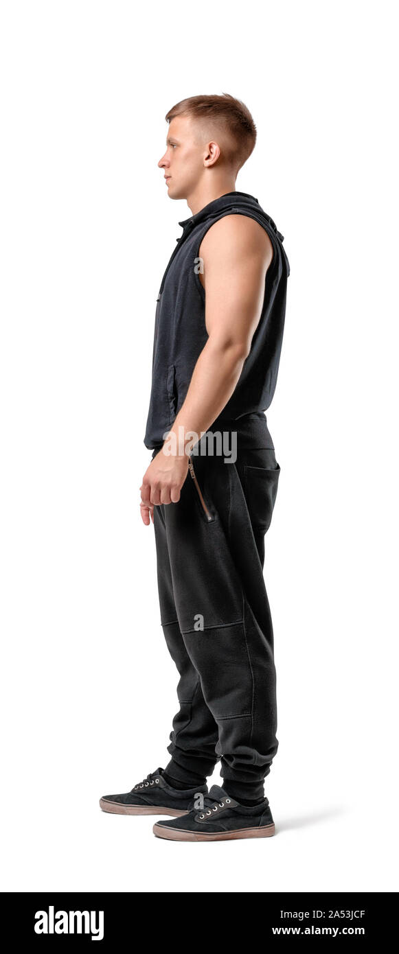 Side view of muscled young man standing, isolated on white background ...