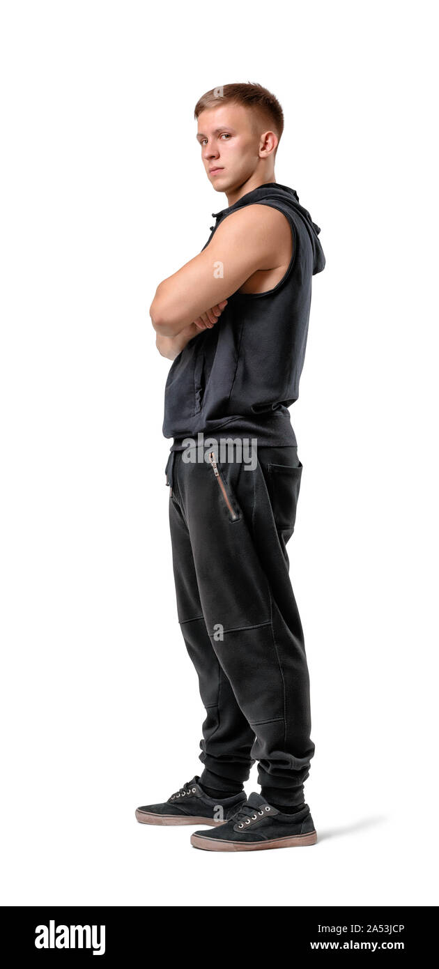 Side view of muscled young man standing with his arms folded looking at ...