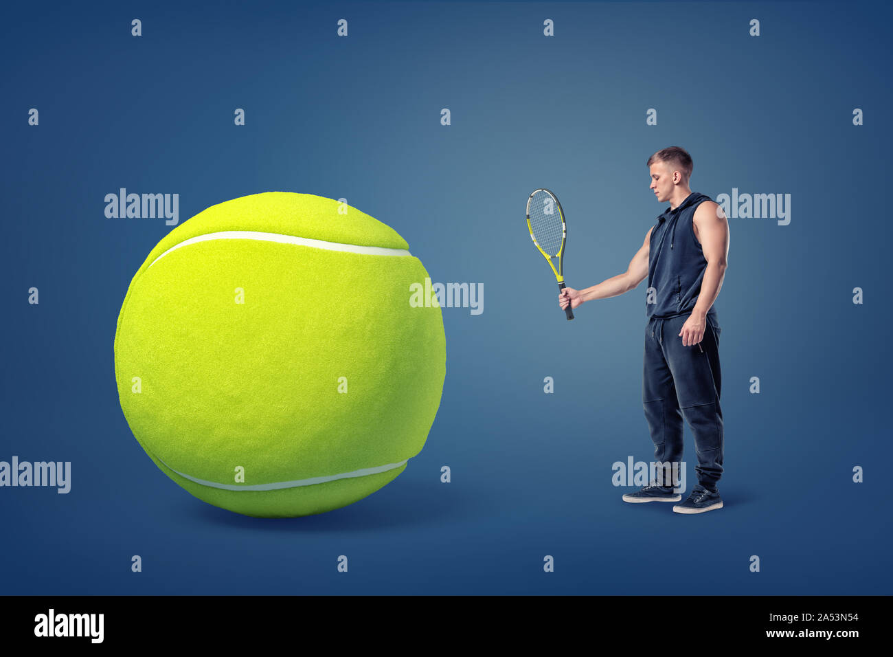 An athletic man stands in a side view holding a tennis racquet in front ...