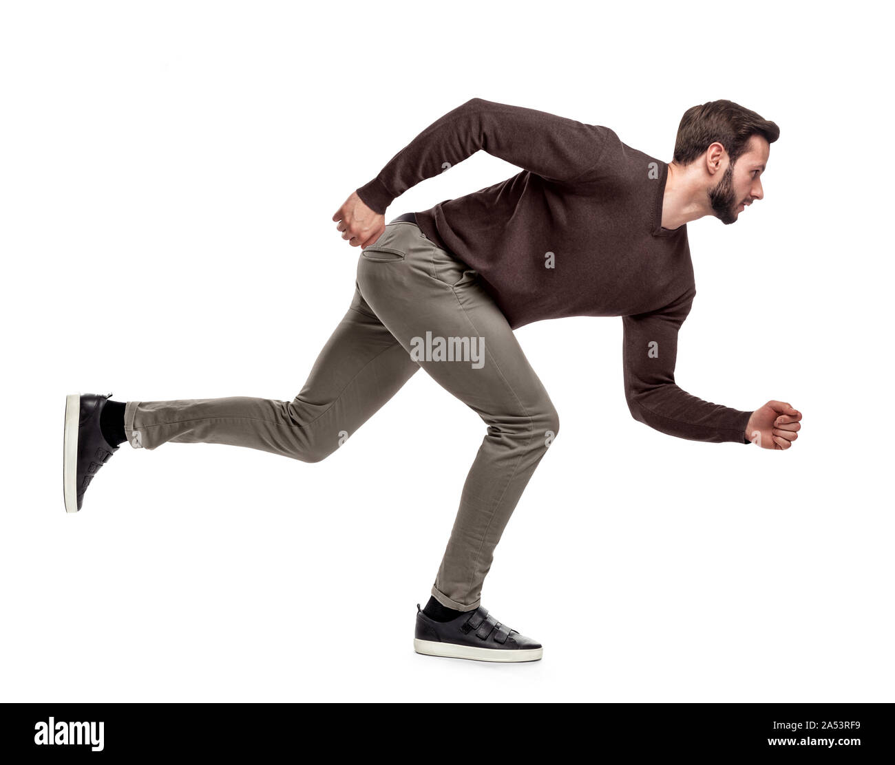 A fit bearded man in casual sweater stands in a low running position ...