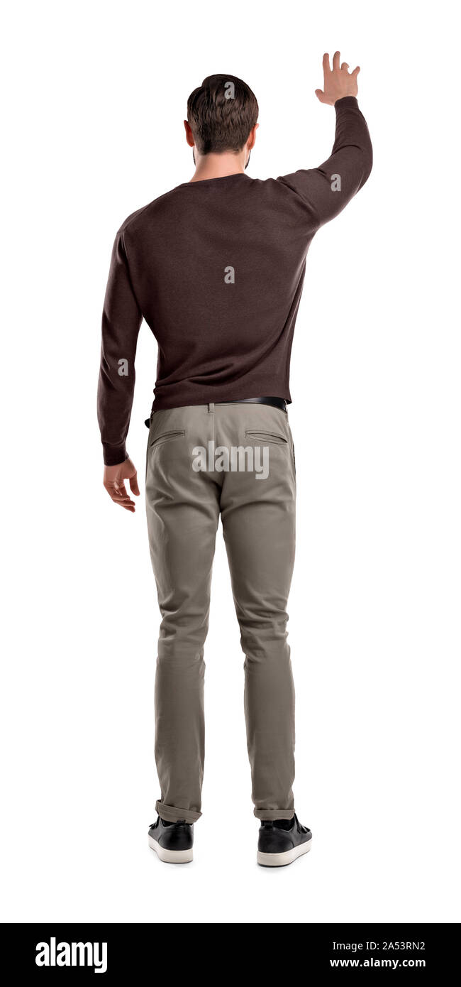 A fit man in casual sweater stands in a back view with one arm lifted ...