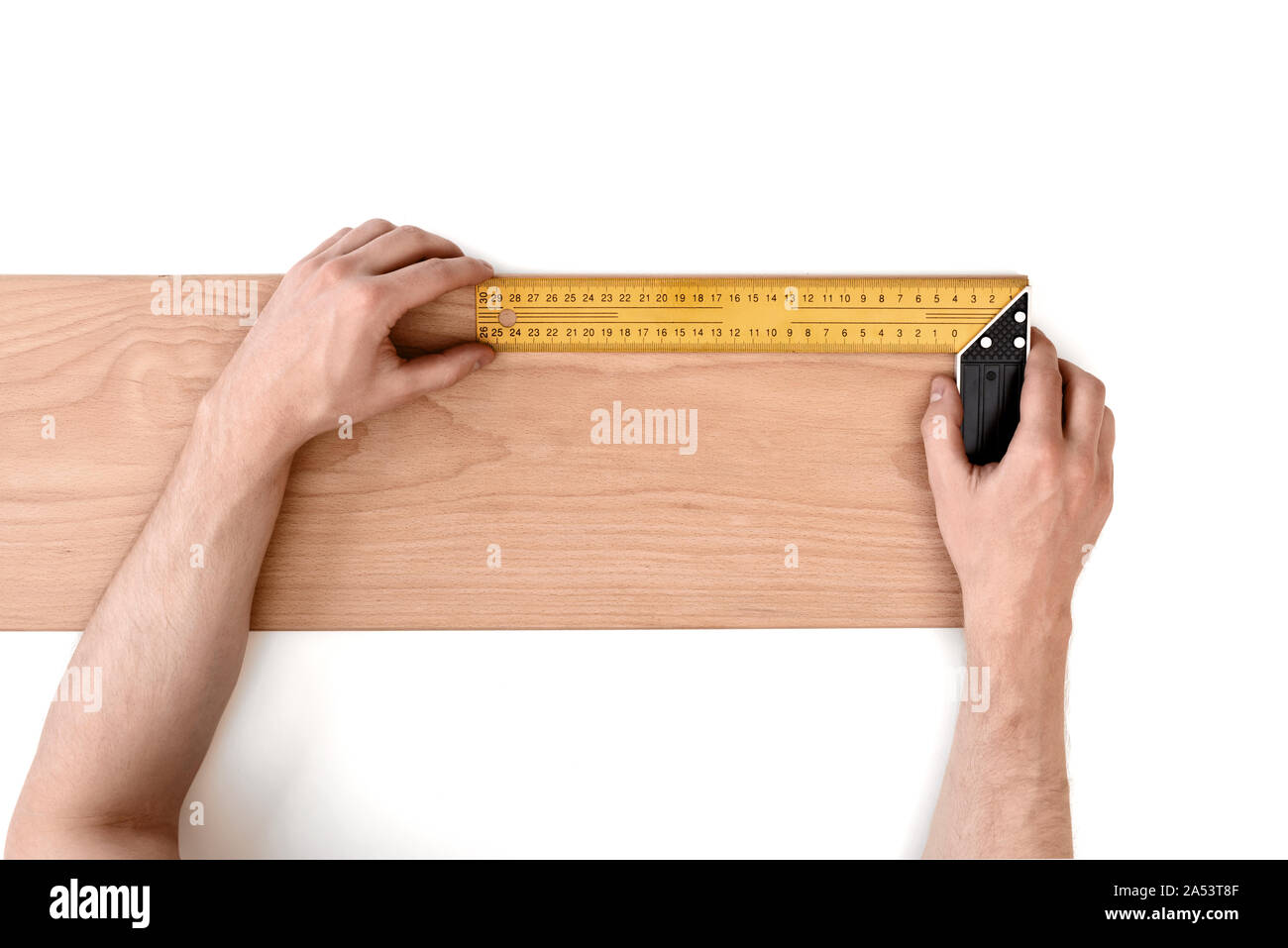 Man's hands measuring wooden plank with a iron ruler, isolated on white ...