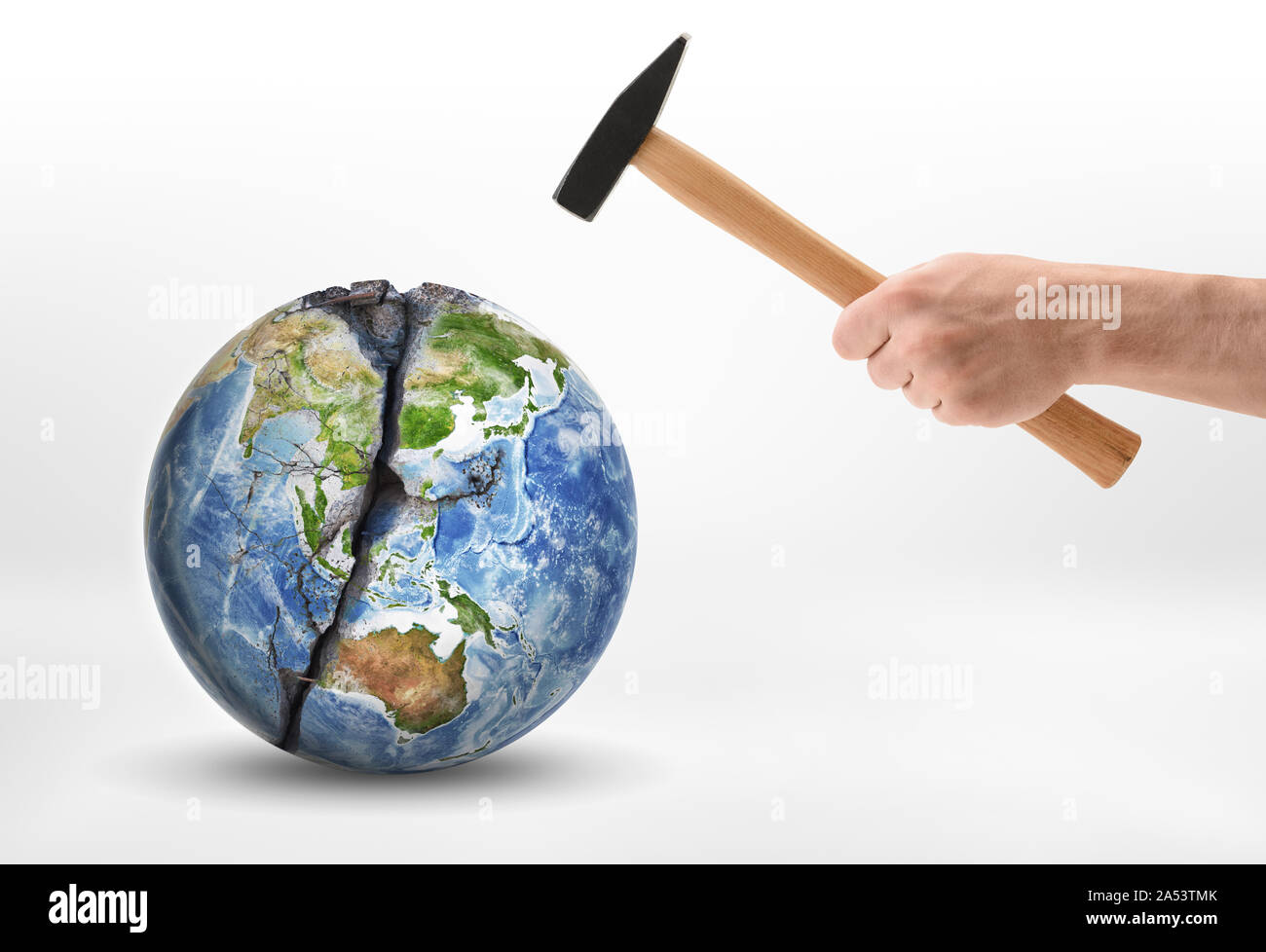 Man's hand with a hammer hits the planet Earth Stock Photo - Alamy