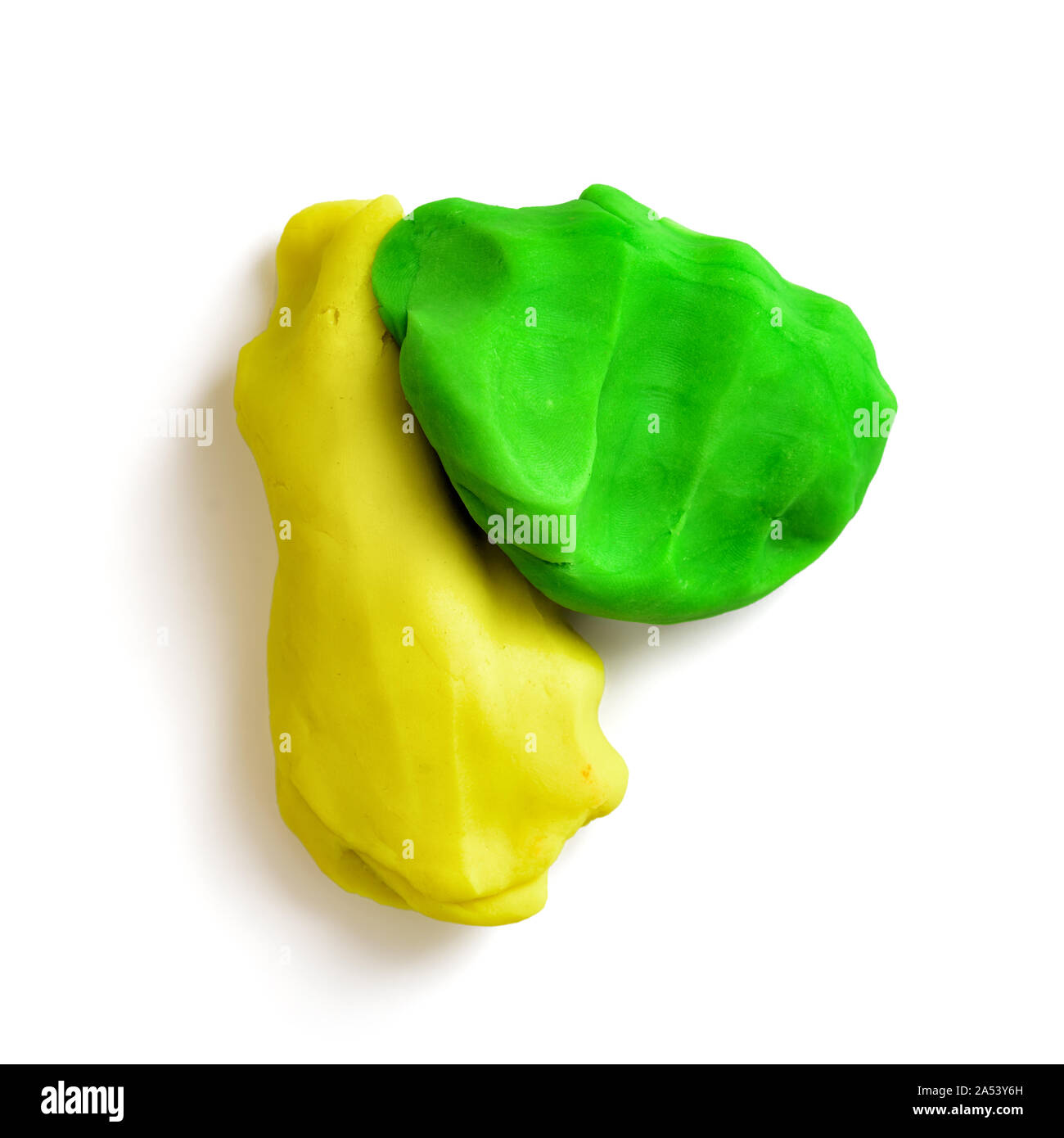 Two pieces of plasticine, yellow and green, isolated on a white ...