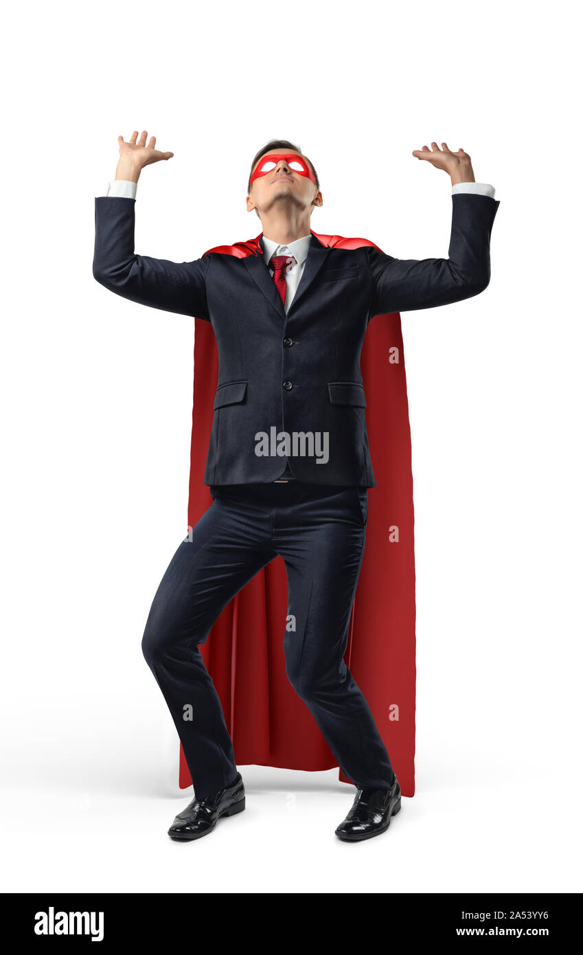 A businessman in superhero costume over his suit trying to hold a heavy ...