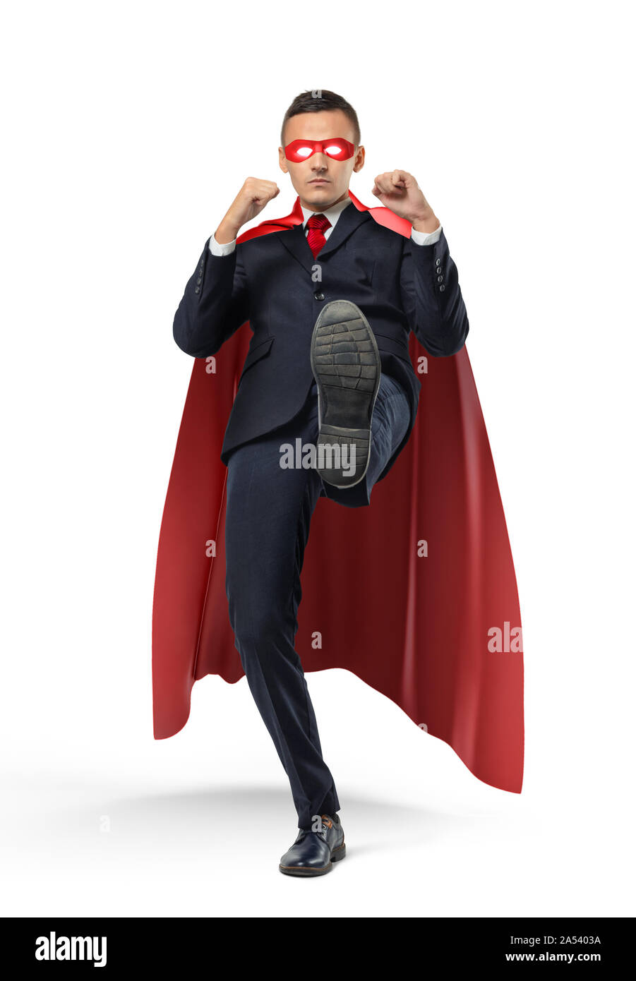 A businessman in a red superhero cape kicking an invisible object on ...