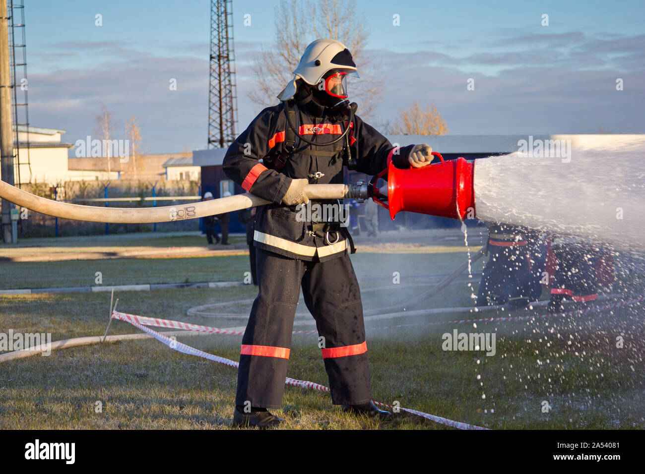 Fireman with fire extinguishing foam spraying hose Stock Photo - Alamy