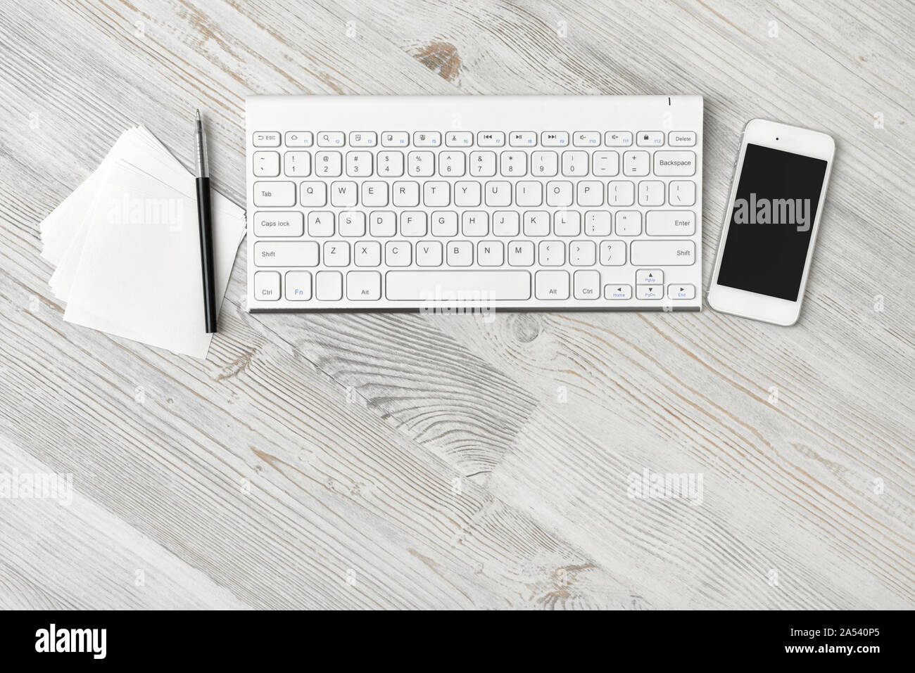 Workstation at a white rustic wooden desk Stock Photo - Alamy