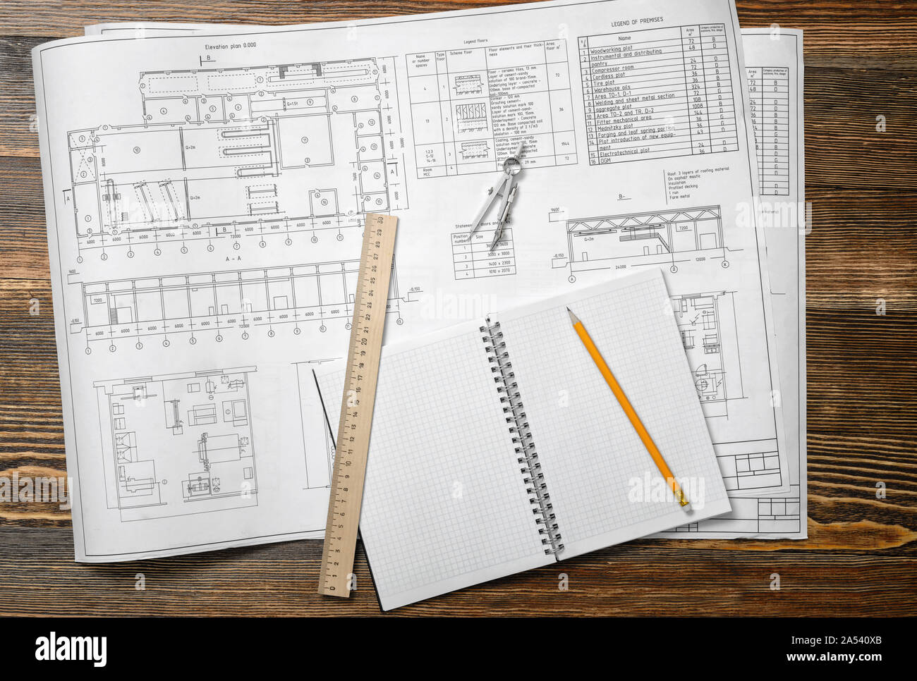 Open blueprints on wooden table background with a pencil, a ruler and ...