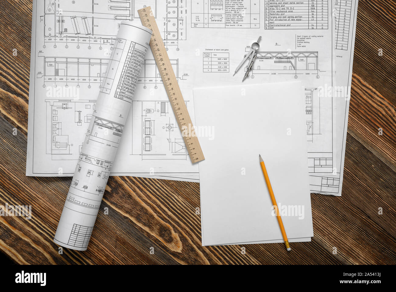 Blueprints on wooden table background with a pencil, a ruler and ...