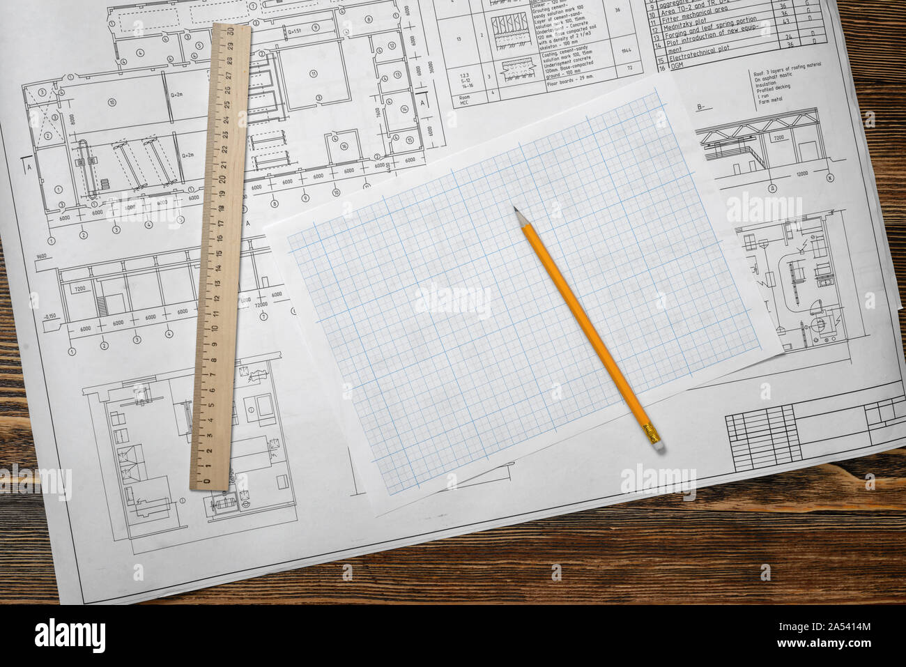 Open blueprints on wooden table background with a pencil and a ruler ...