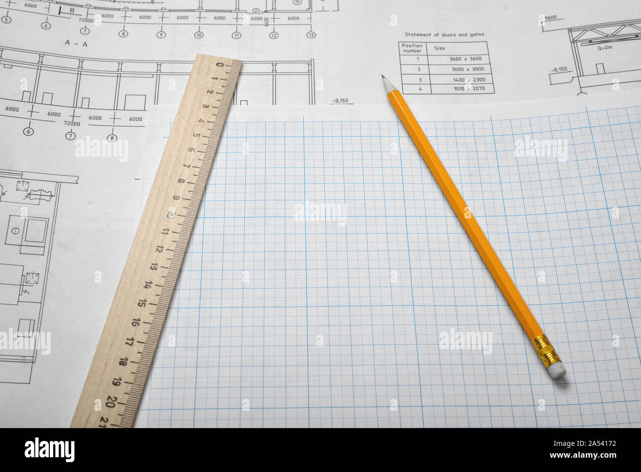 Open blueprints on wooden table background with a pencil and a ruler ...