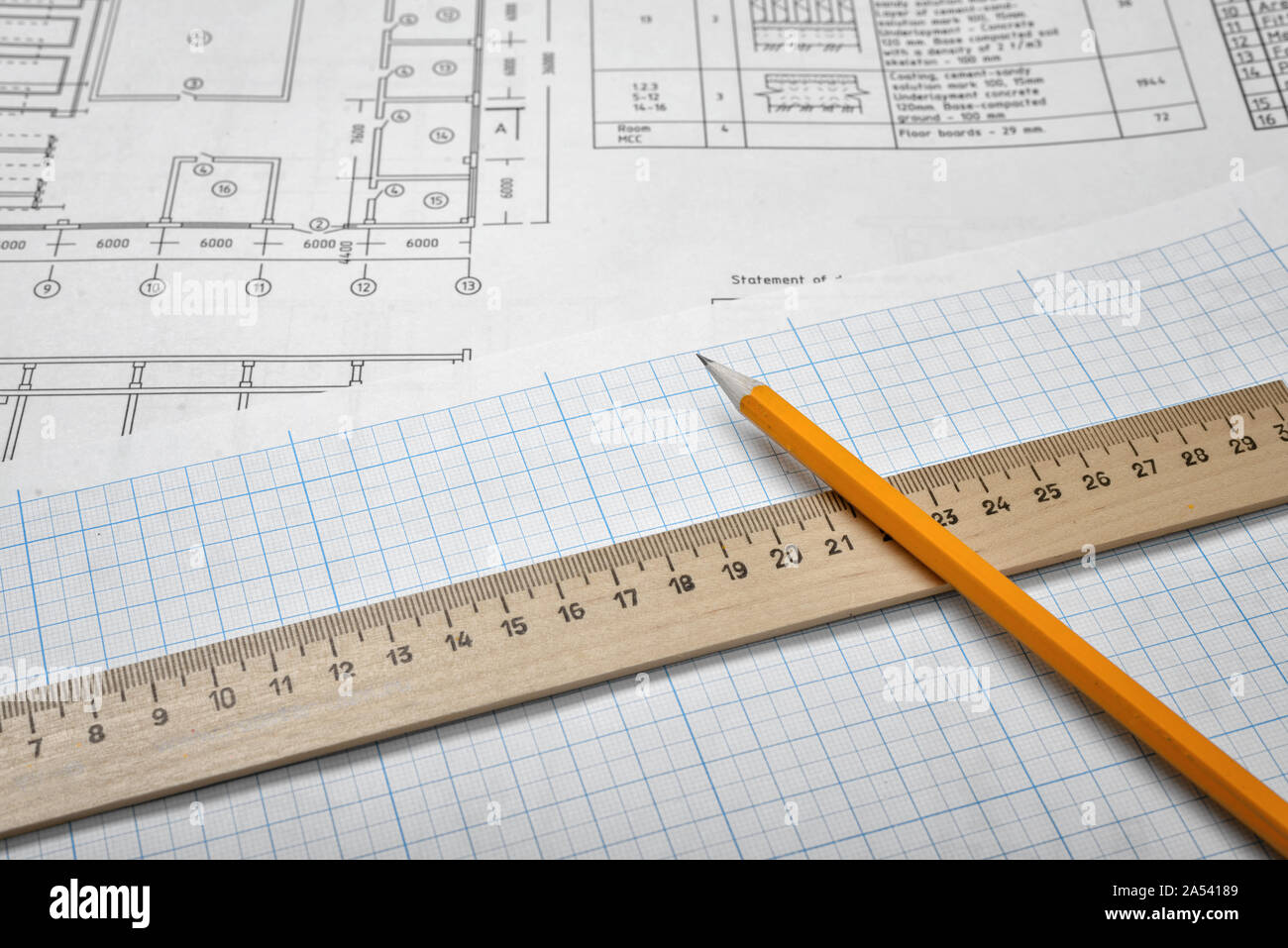 Open blueprints on wooden table background with a pencil and a ruler ...