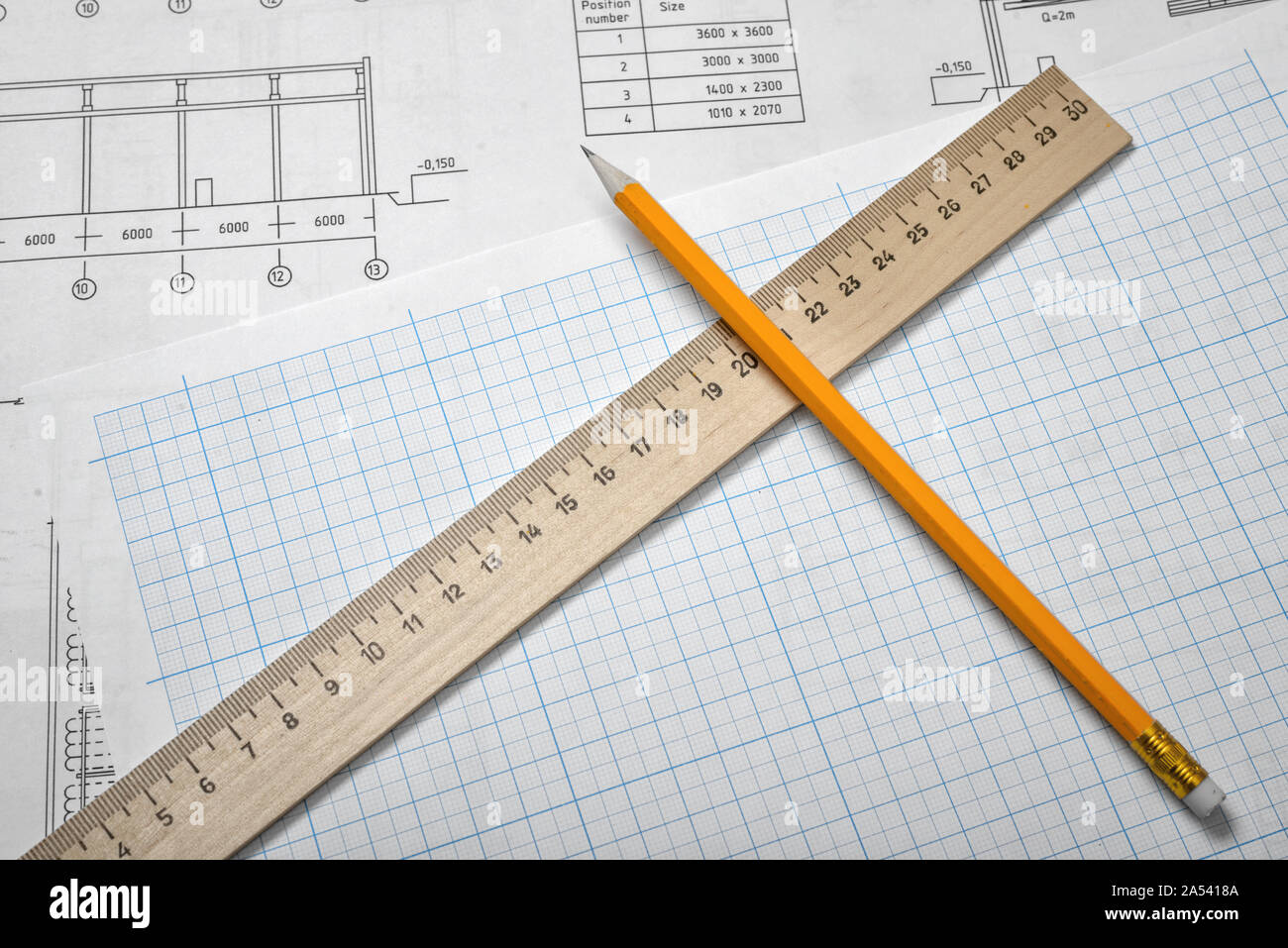 Open blueprints on wooden table background with a pencil and a ruler ...