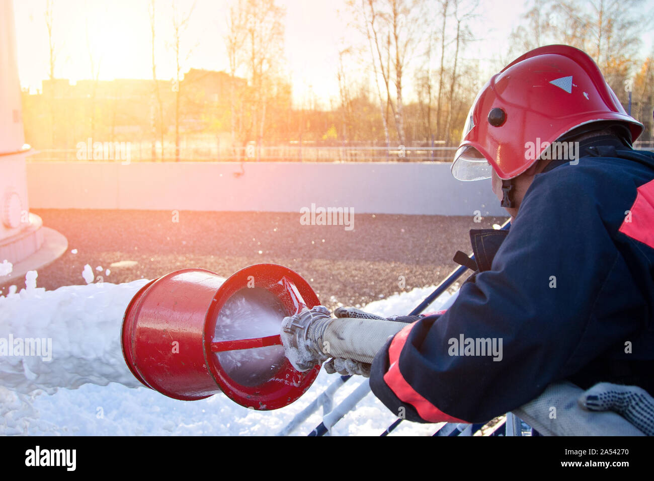Fireman extinguish fire by foam spraying hose Stock Photo - Alamy