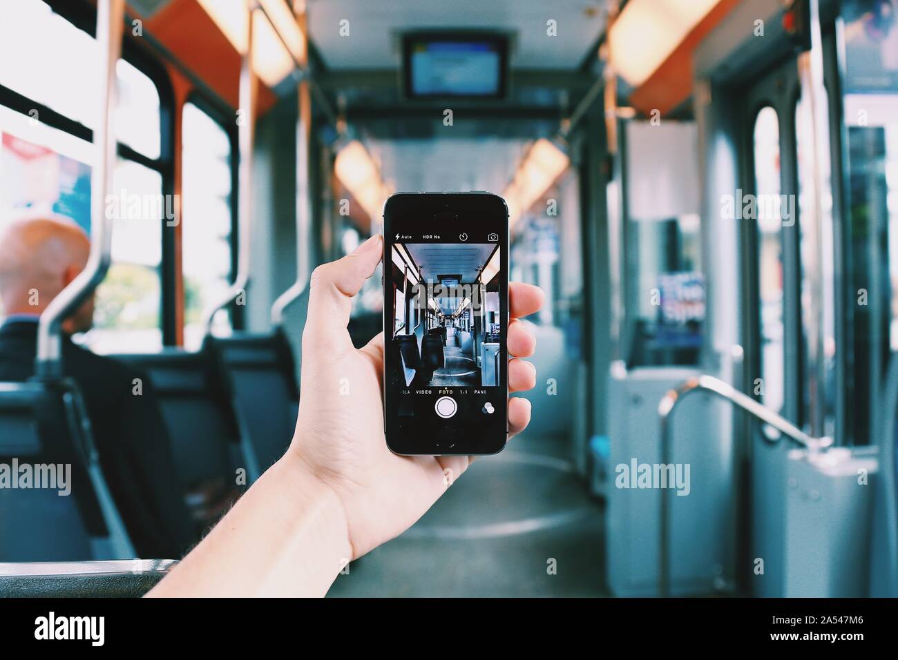 Person with a smartphone taking a picture of the inside of a bus ...
