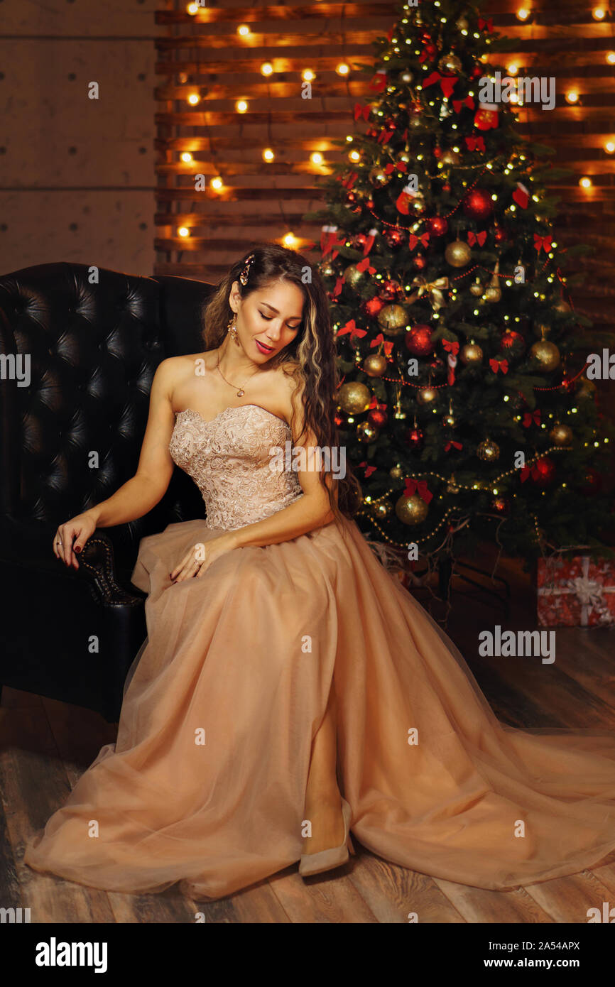Elegant lady in luxury dress over christmas tree lights background ...