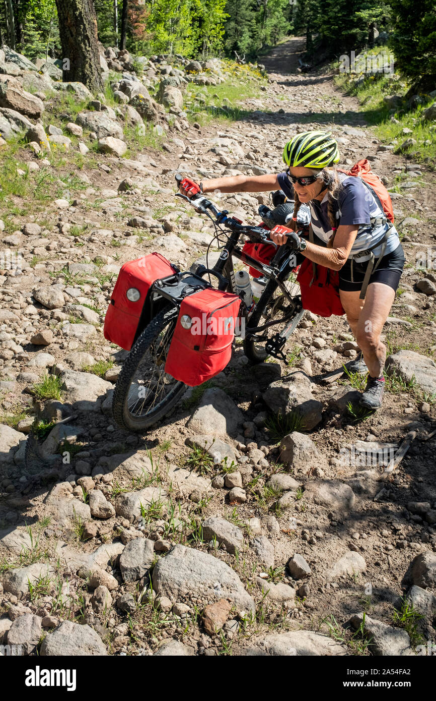 NM00150-00...NEW MEXICO - Vicky Spring walking her bike up a steep ...