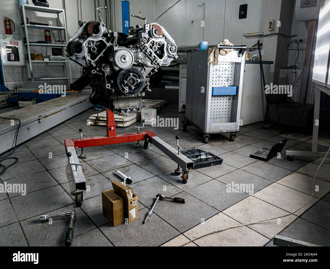 Used v8 engine mounted on a crane for installation on a car after a ...