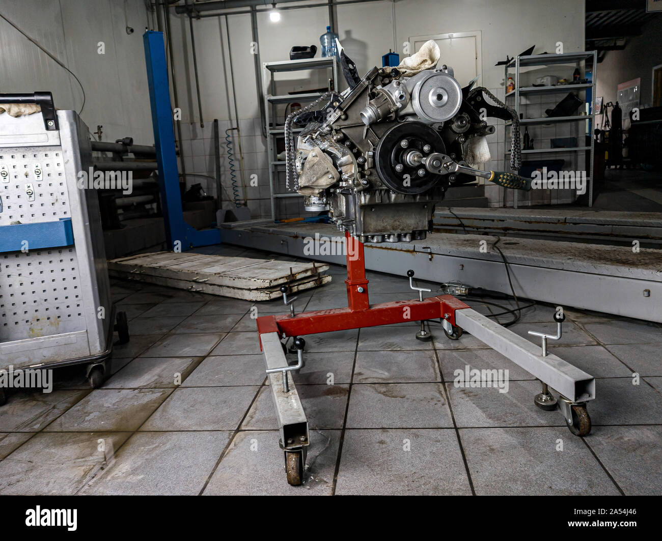 Used v8 engine mounted on a crane for installation on a car after a ...