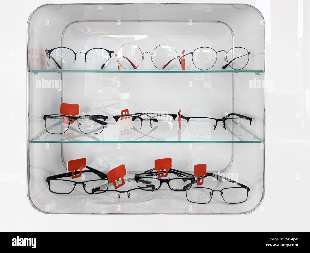 Shelving with glass shelves with glasses and frames in the optics store ...