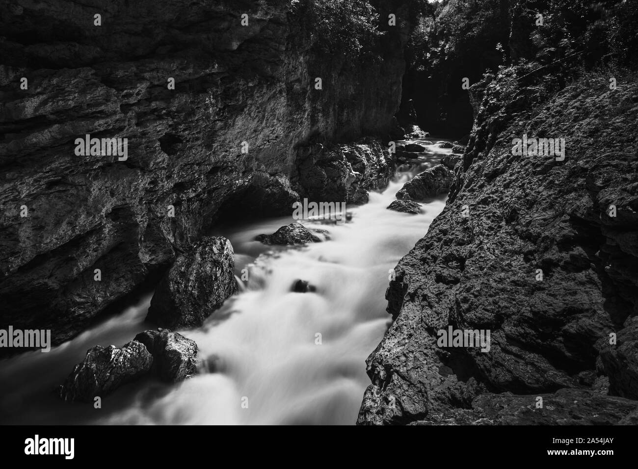 High angle shot of water flowing in between two cliffs in black and ...