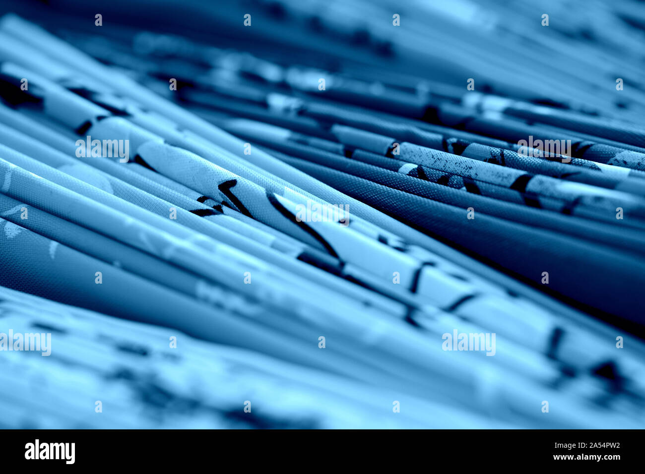 Folded Vietnamese fans on a dark background close-up. Blue color toned ...