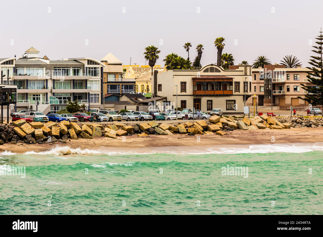 Sea waves, coastline cars and buildings on the street of Swakopmund ...