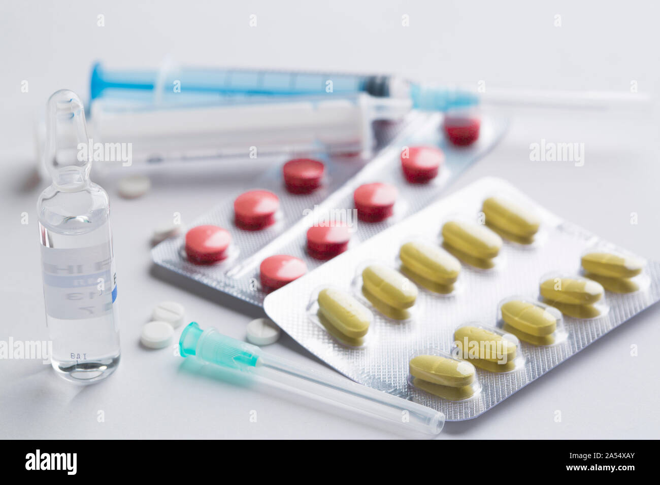 Assortment of pills and tablets on white background. Syringe for ...