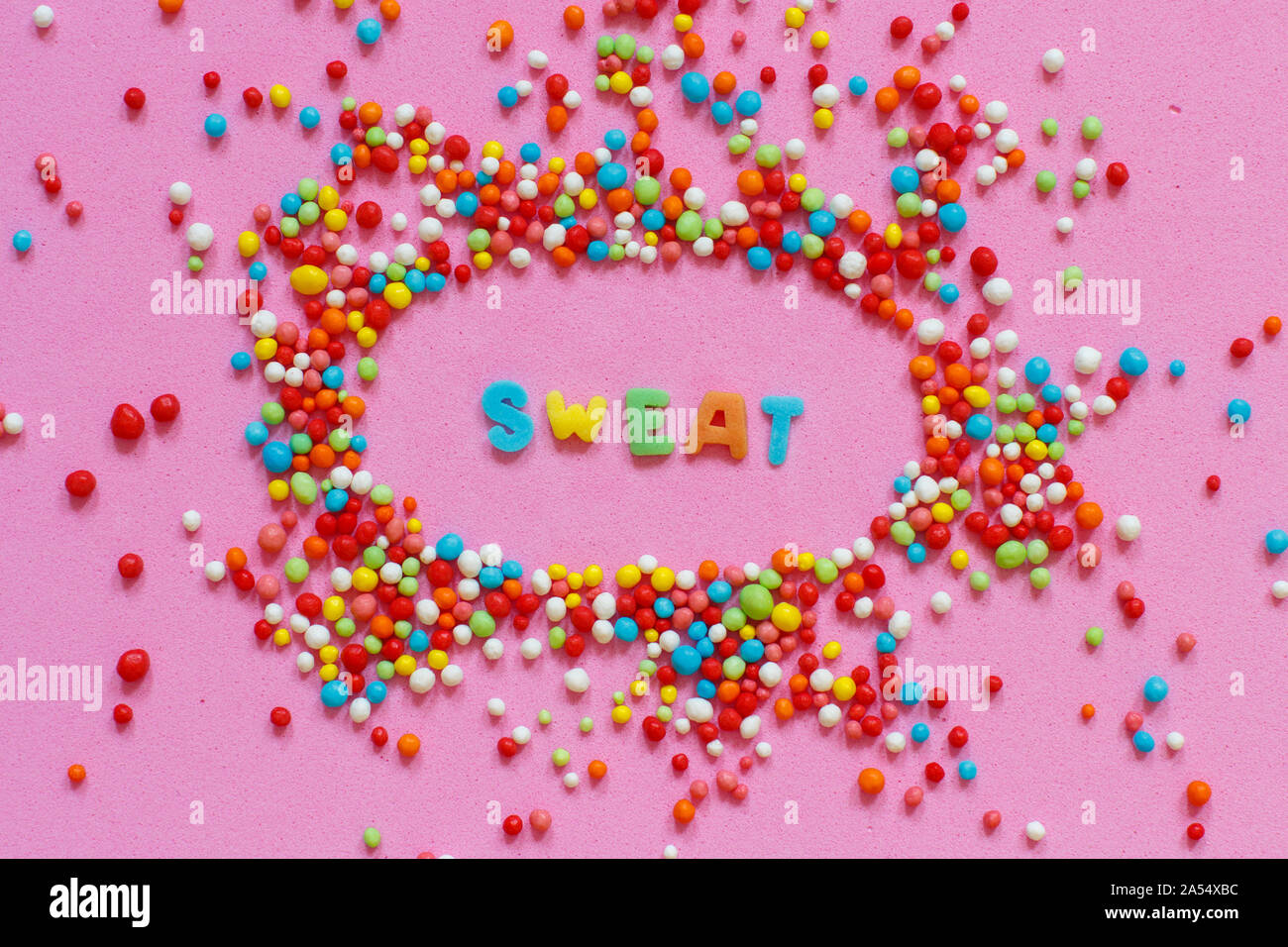 Colorful sugar sprinkles and a word Sweet on a bright pink background ...