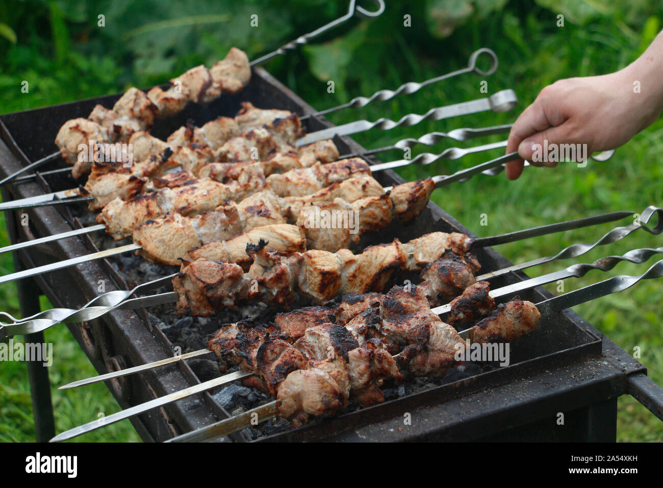 Cook cooks barbecue skewers. Marinated kebab is grilled on charcoal ...