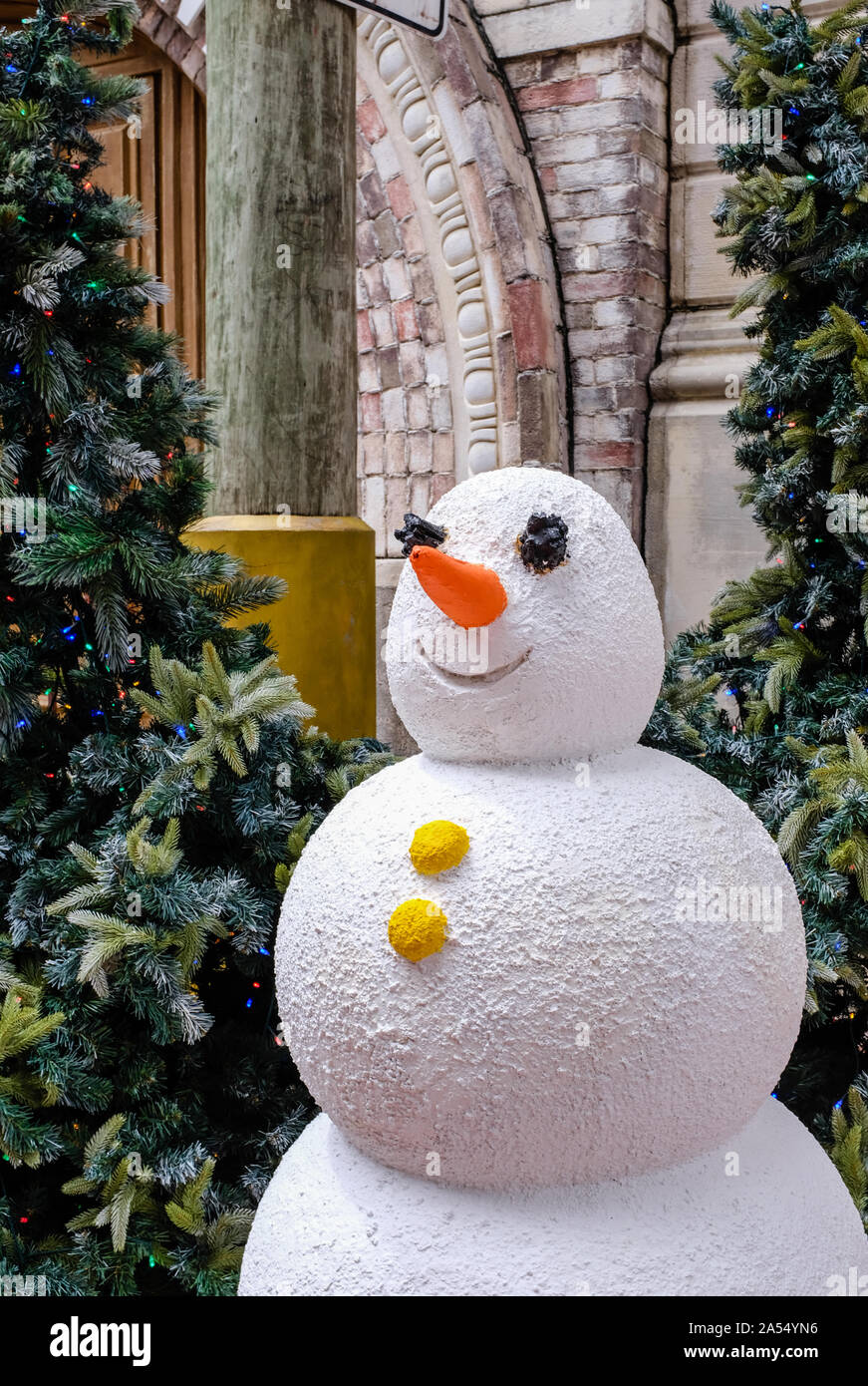 cute plastic snowman display in front of wood wall Stock Photo - Alamy