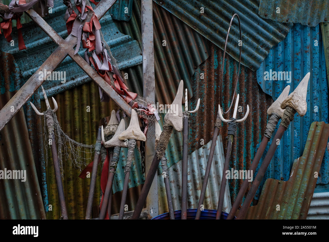 Ancient bone weapon display in front of rusty wall Stock Photo - Alamy