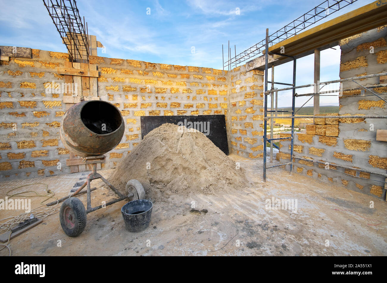 Home building. Concrete mixer and heap of sand. Architecture and ...
