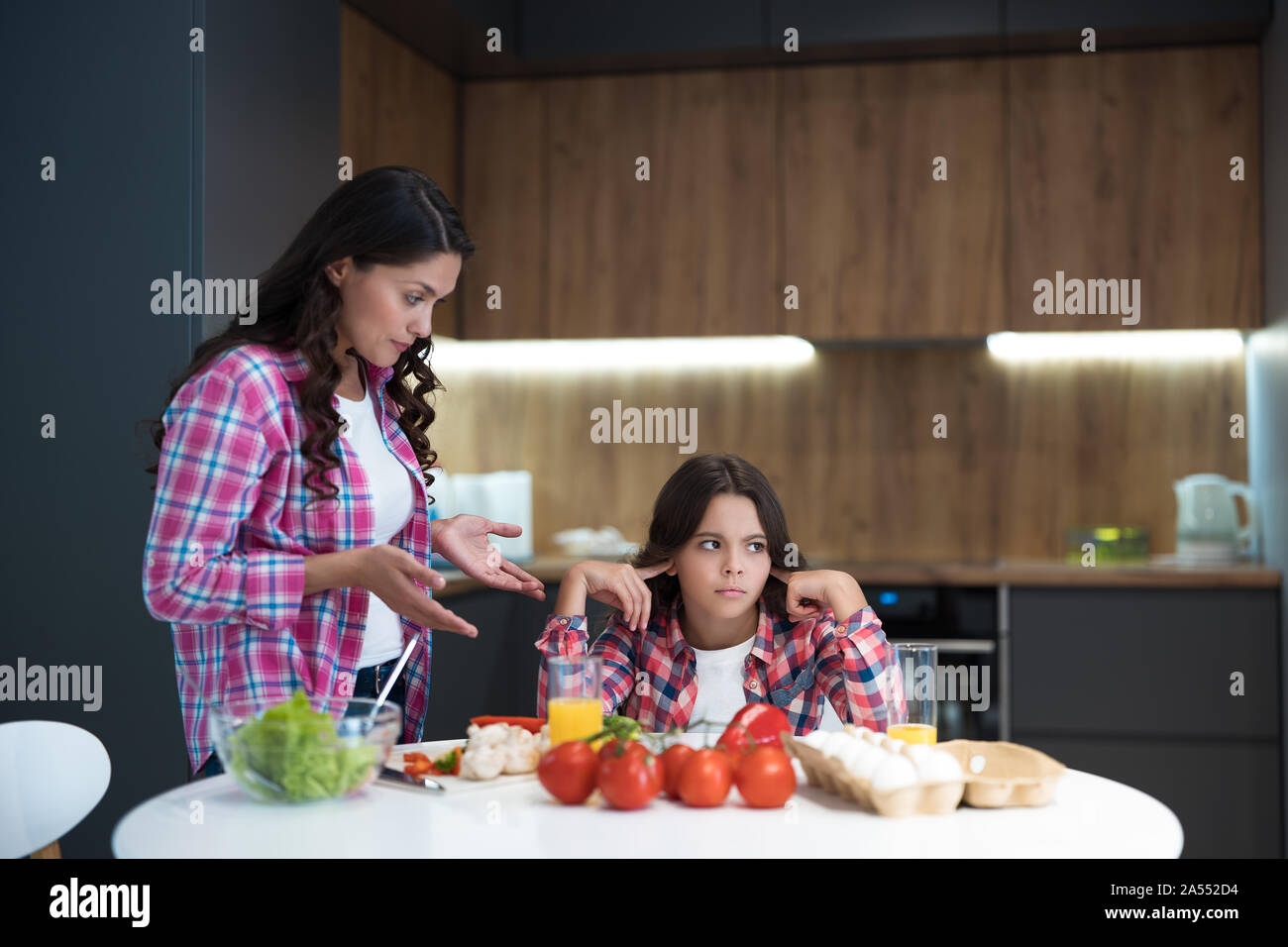 young beautiful woman having fighting with her teen daughter during ...