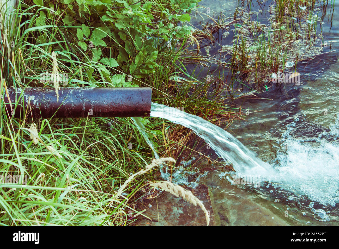 Sewage flows into the lake, river. Water flows from the pipes ...