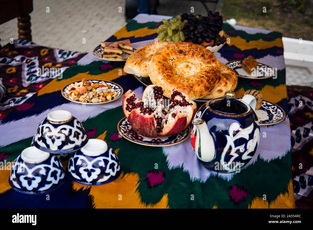 Traditional Uzbek bread on the table with mugs and kettle. Cuisine of ...