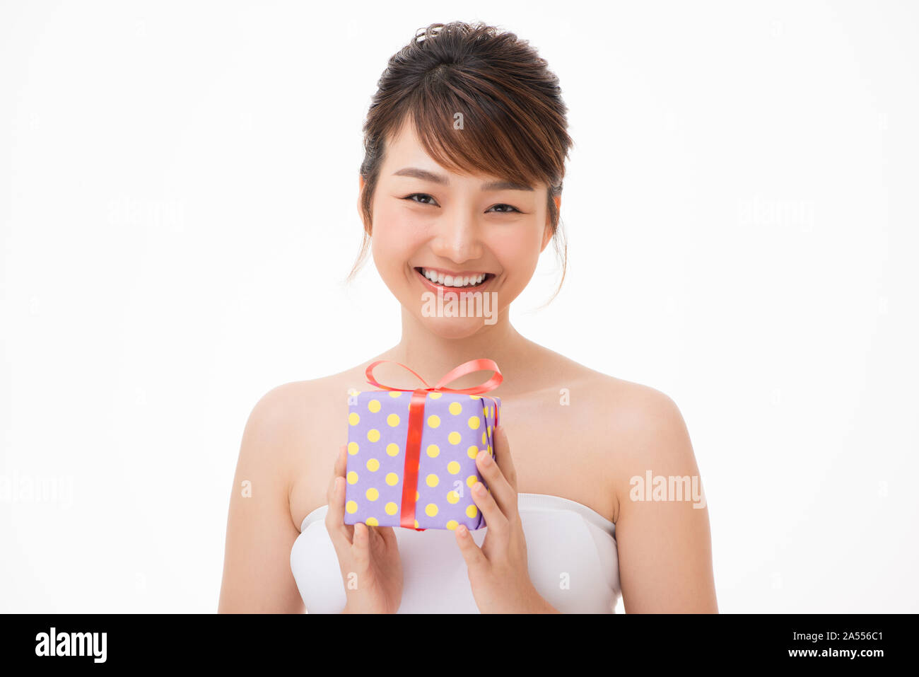 A portrait of beautiful girl holding a gift box isolated on white ...