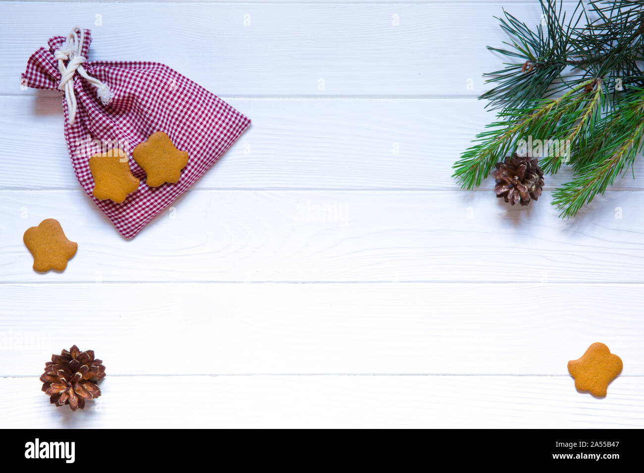 Christmas conceptual background, red and white chequered bag, ginger bells cookies, pinecone on ...