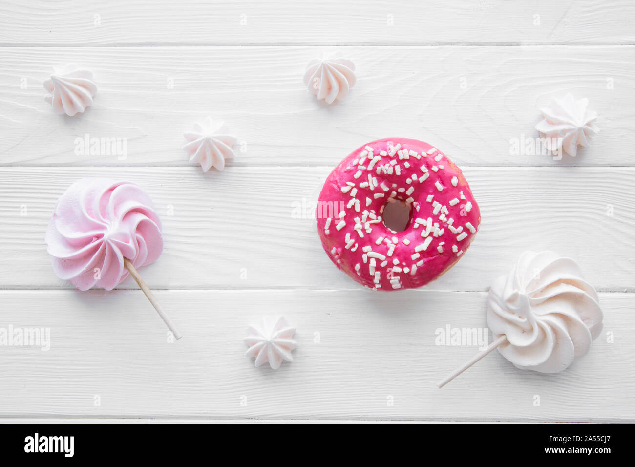 Pink doughnuts and pink and white meringue sweets background. Bright ...
