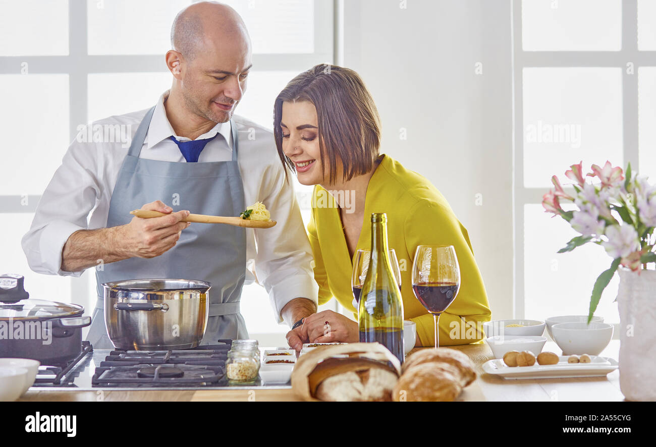 Smiling young couple cooking food in the kitchen Stock Photo - Alamy