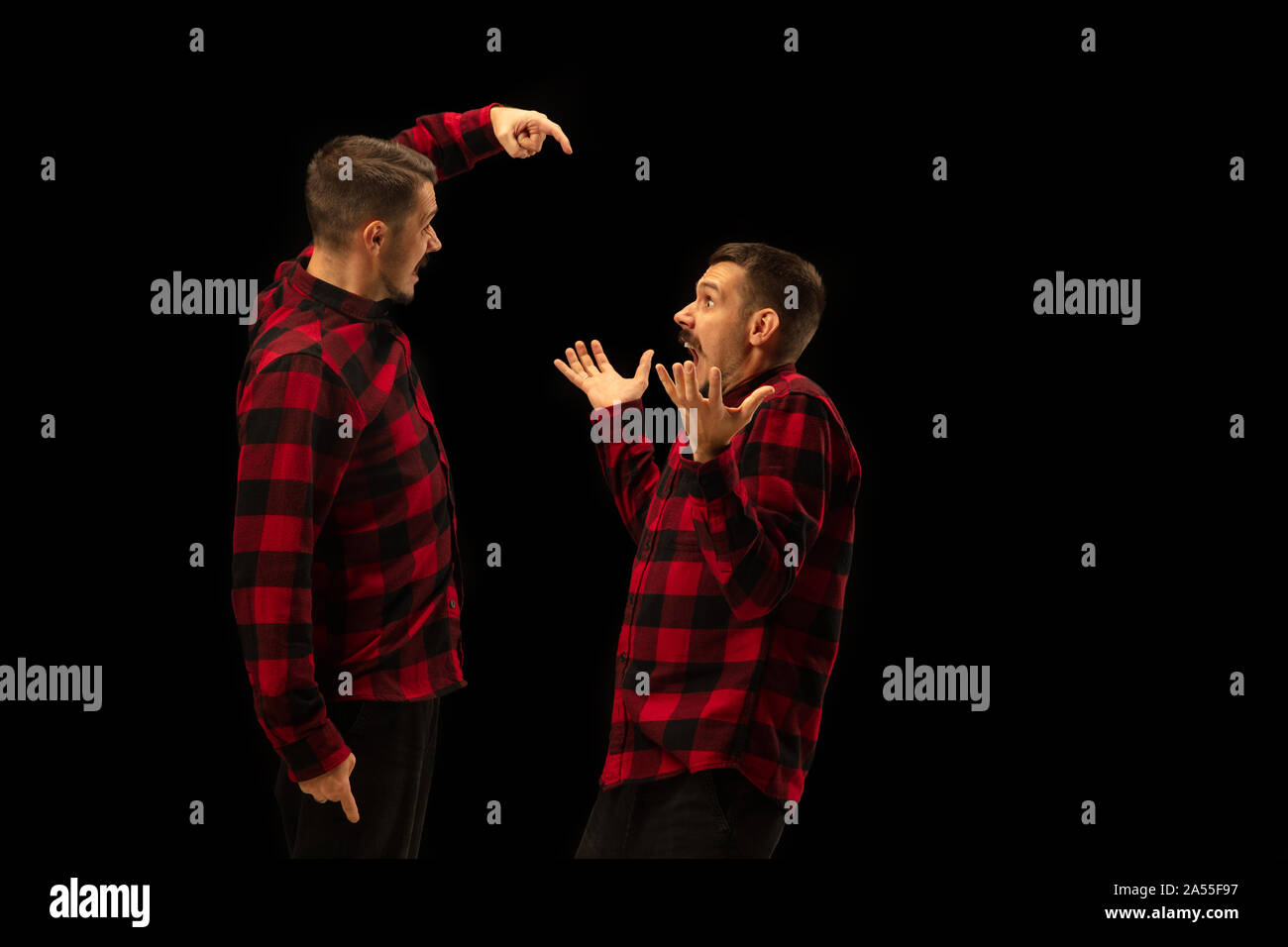 Young handsome man arguing with himself on black studio background ...