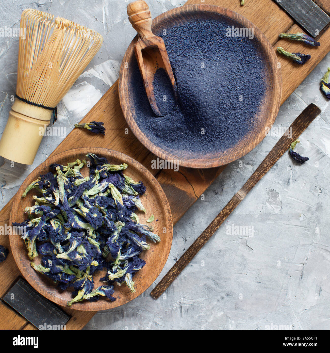 Butterfly pea blue matcha powder word with wrisk and dried flowers ...
