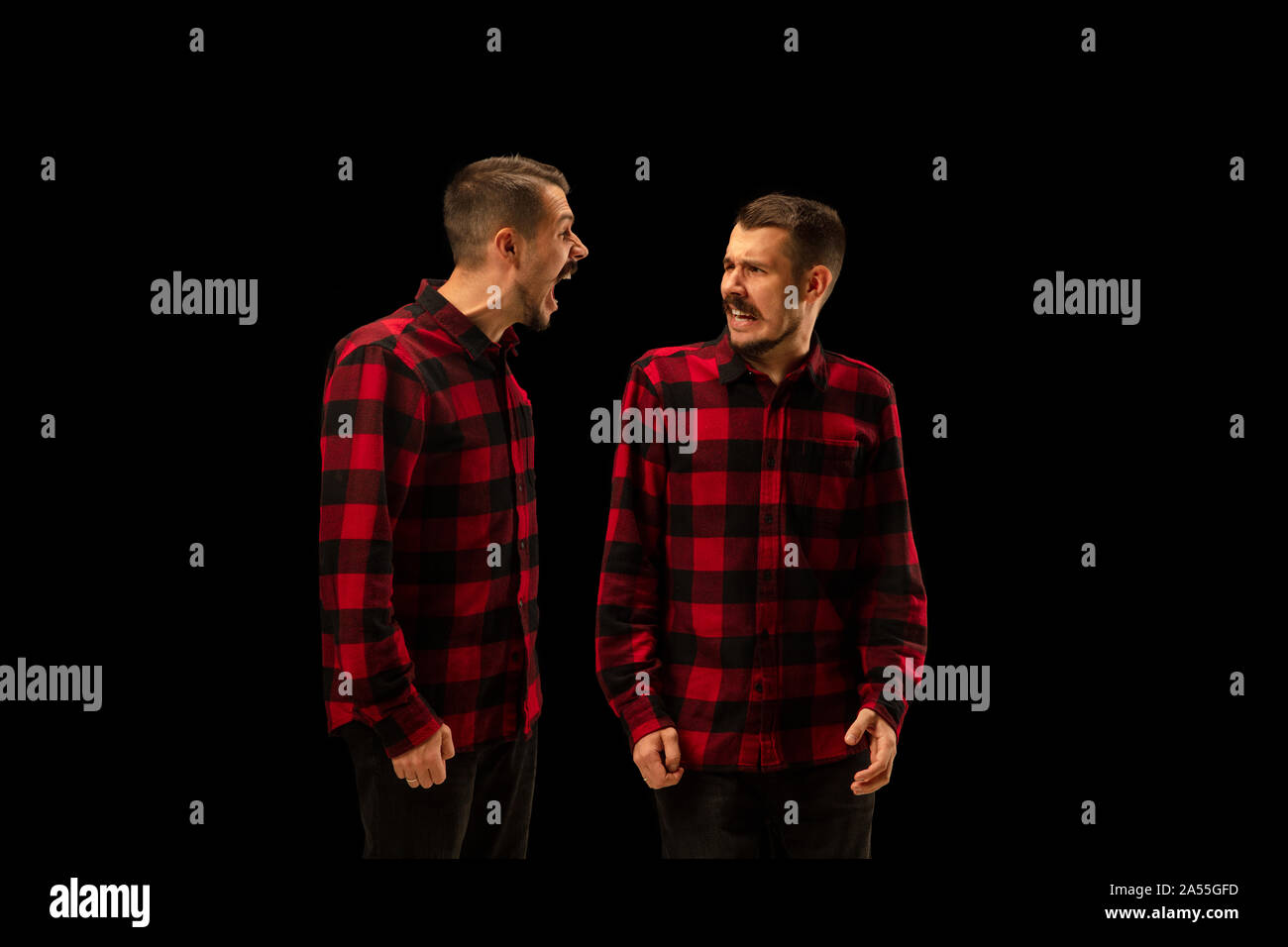 Young handsome man arguing with himself on black studio background ...