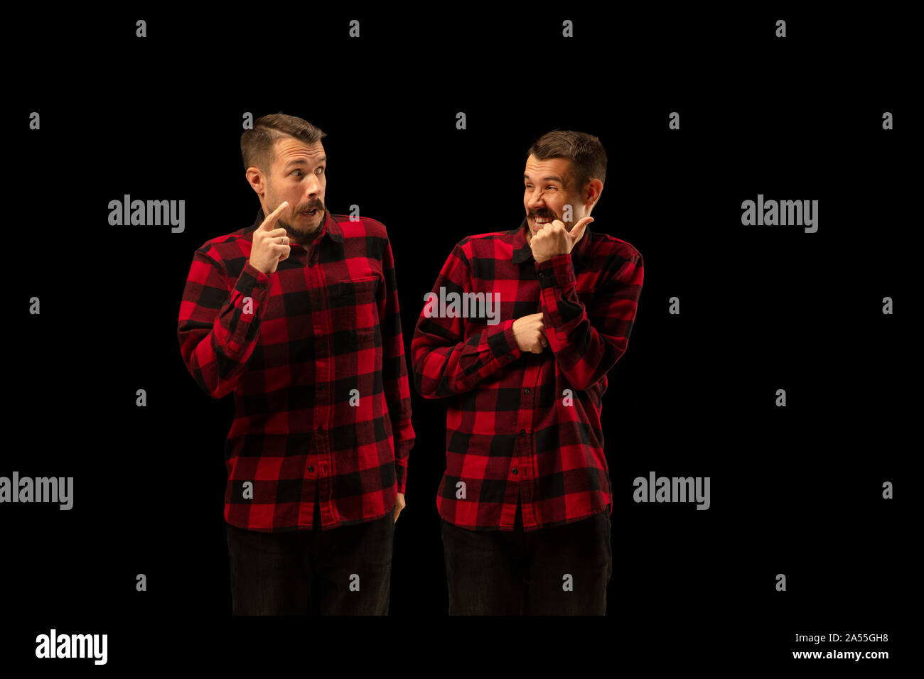 Young handsome man arguing with himself on black studio background ...