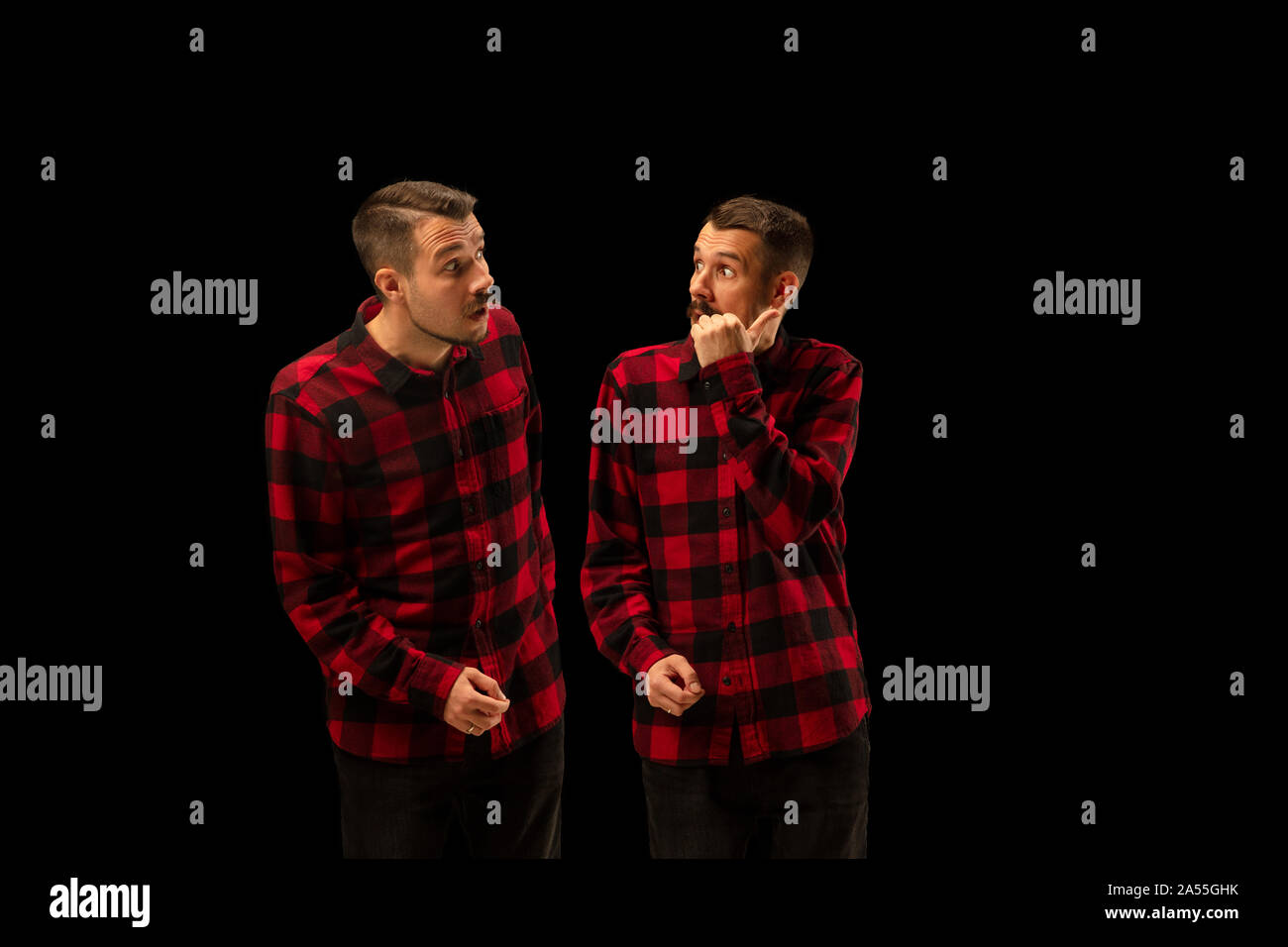 Young handsome man arguing with himself on black studio background ...